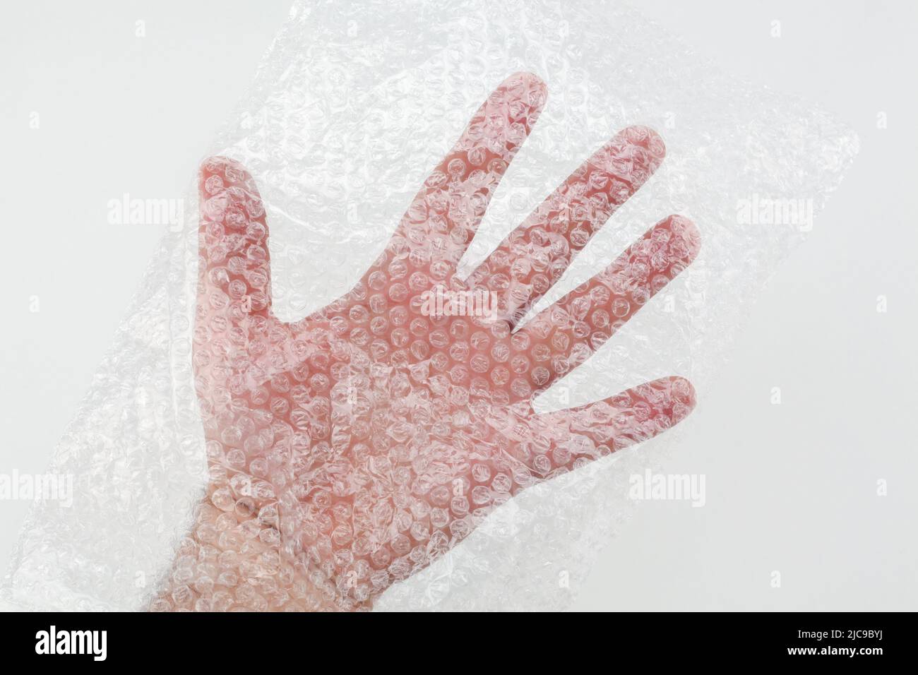 Male hand in plastic wrap with pimples. Man's hand in a plastic bag ...