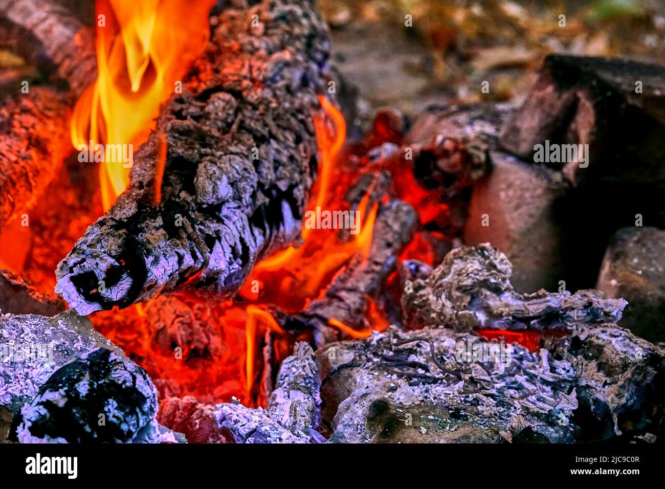 Campfire with fading flame and smoldering coals. Time for cooking meat ...