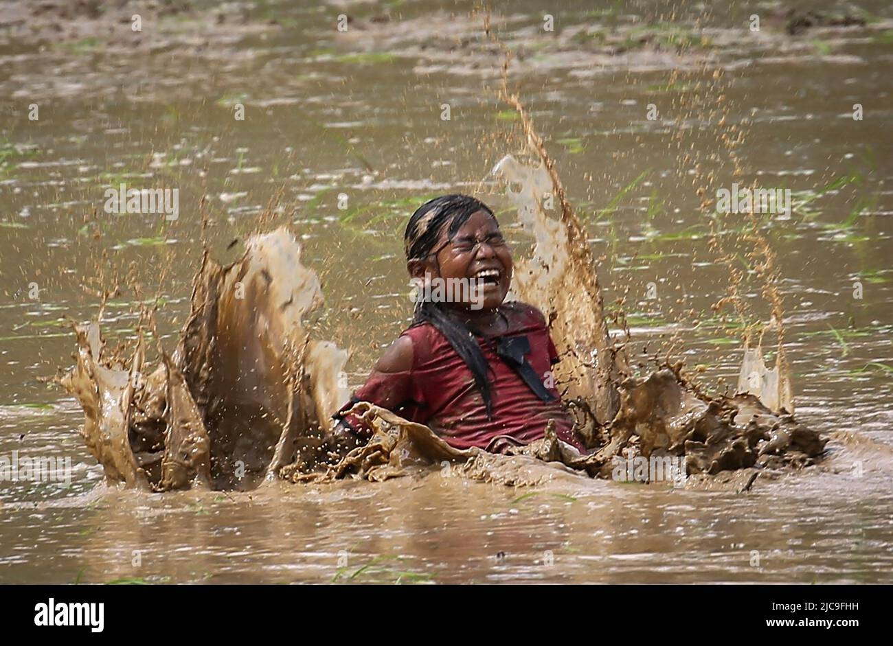 Kathmandu, Bagmati, Nepal. 11th June, 2022. A small girl jumps on muddy ...