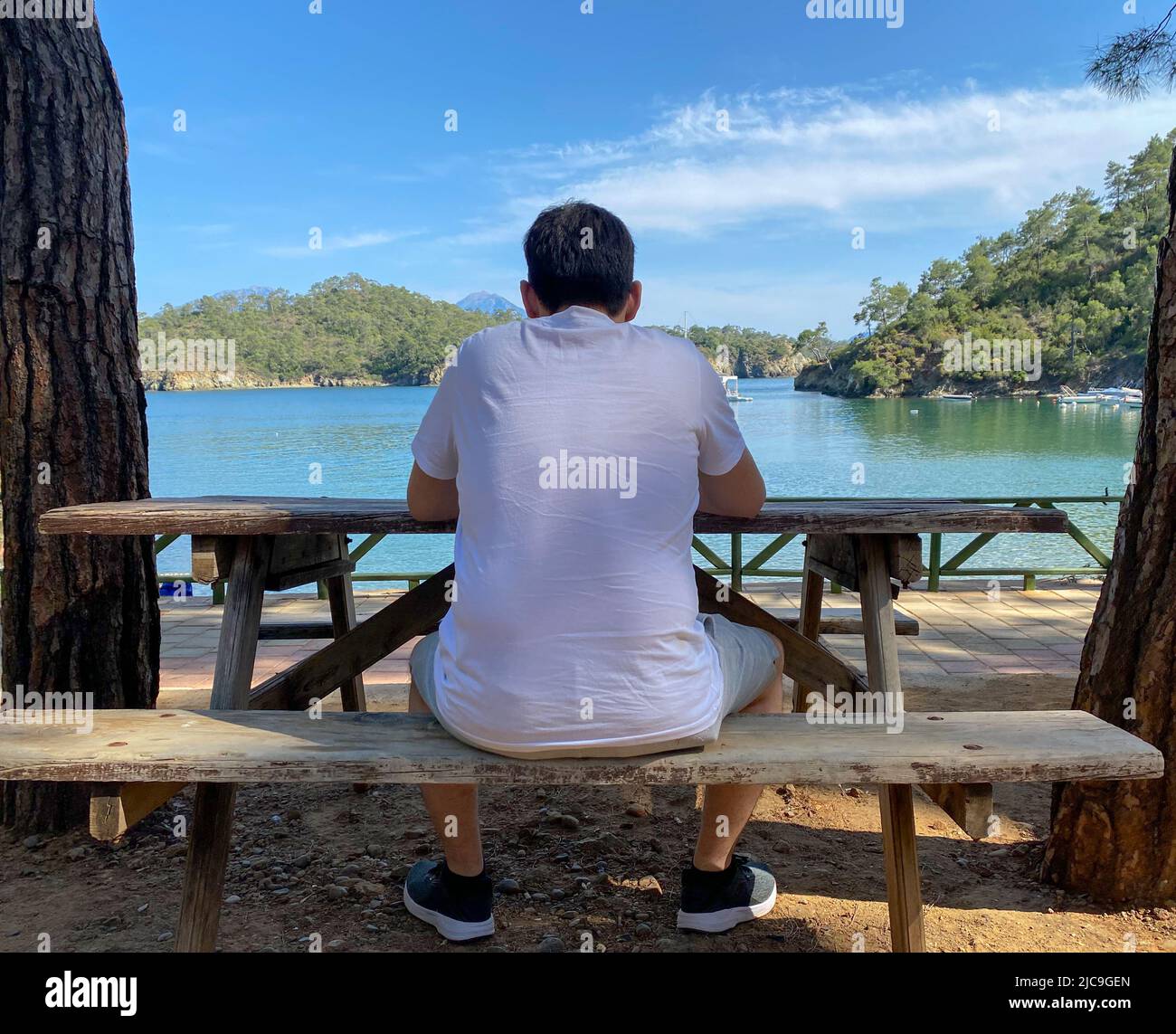 man sitting on bench watching sea or lake or bay view. at katranci bay ...