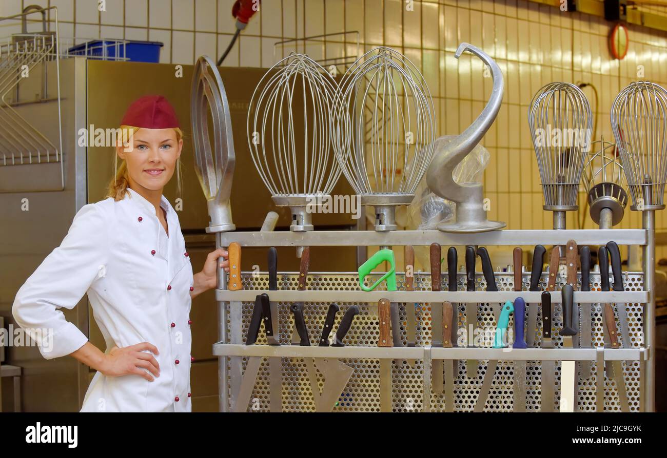 A young baker girl takes up her work in a bakery. She is seen in the ...