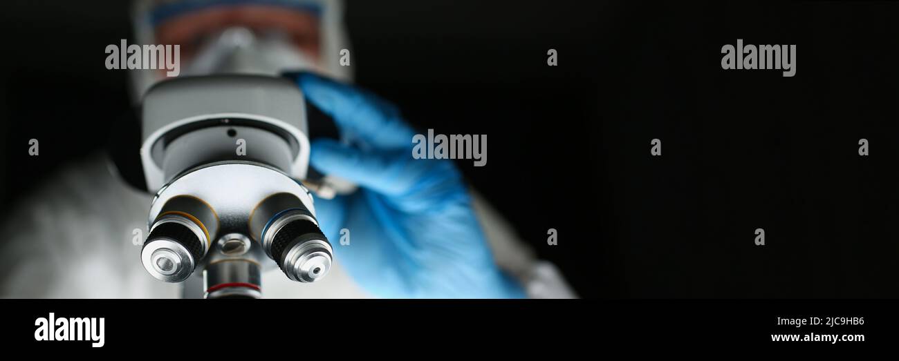 Professional scientist using equipment in modern laboratory while ...