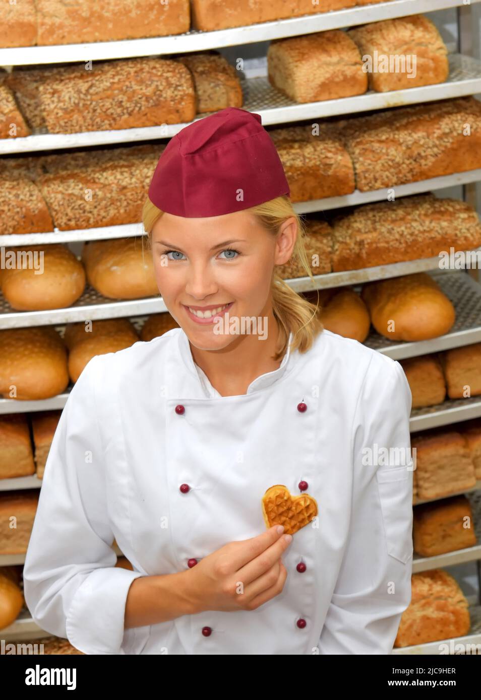 A young baker girl takes up her work in a bakery. She is seen in the ...