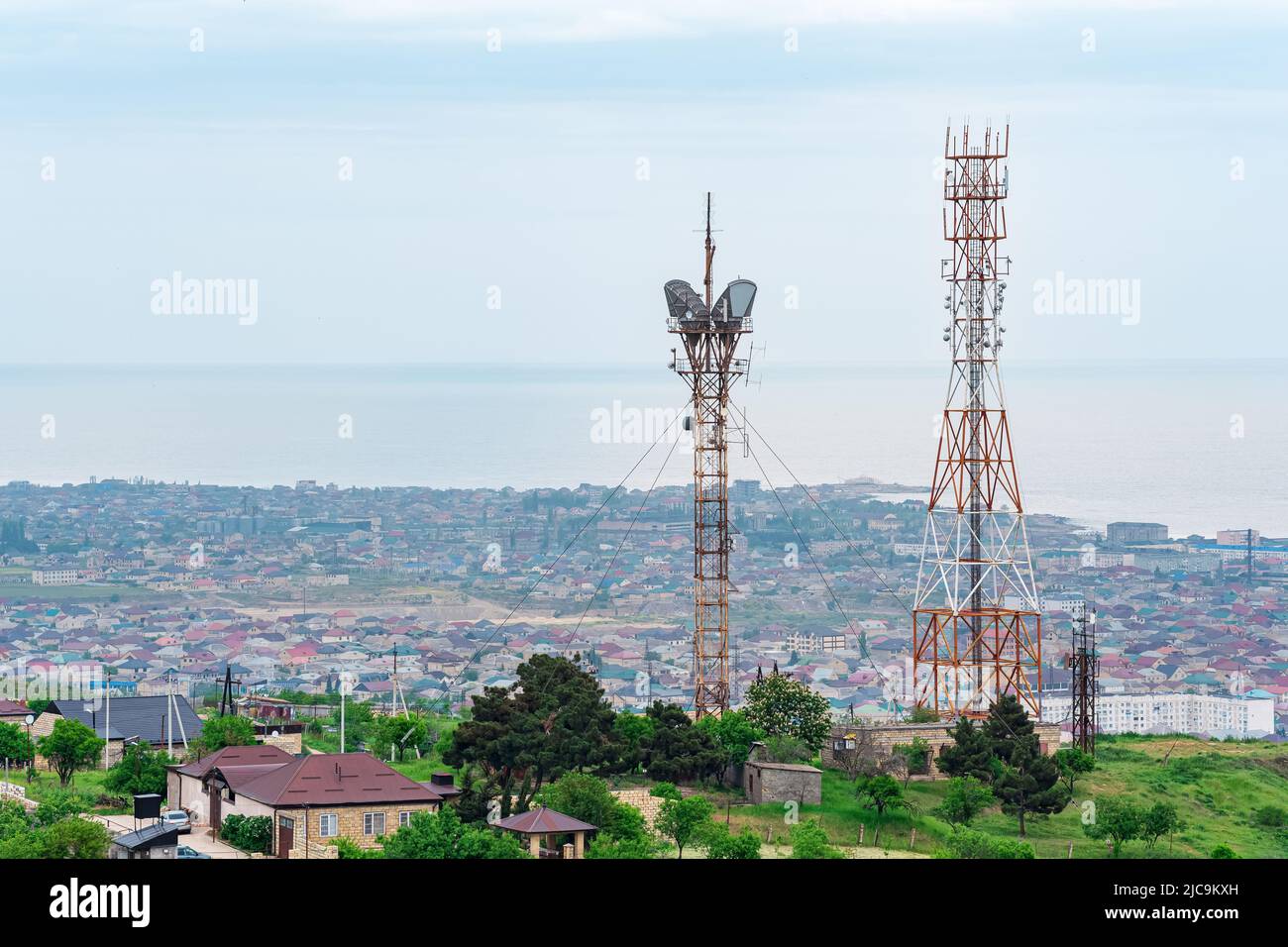 radio communication towers on a mountain above a coastal town Stock ...