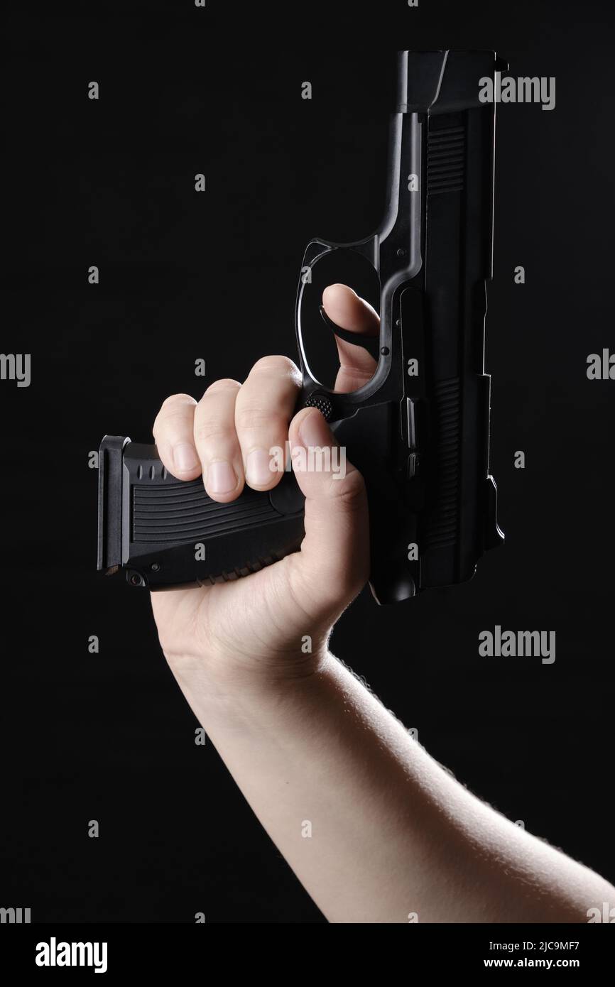 female hand with gun closeup on black background Stock Photo - Alamy