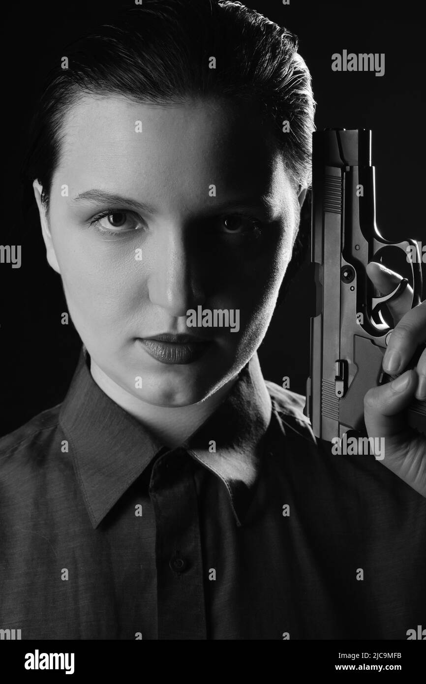 female portrait with gun closeup on black background closeup front view ...