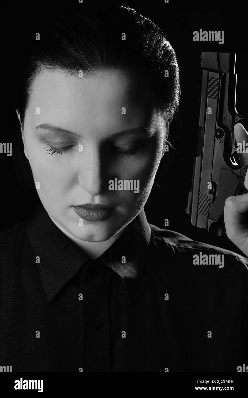 female portrait with gun closeup on black background closeup front view ...