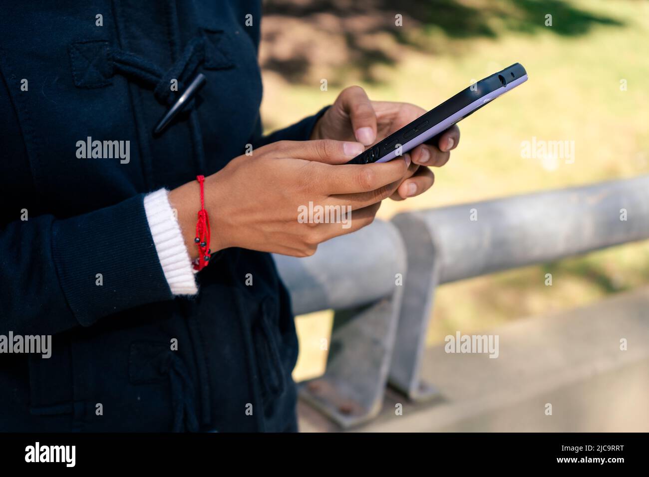 Young woman hands typing a text message on a smartphone or cellphone ...
