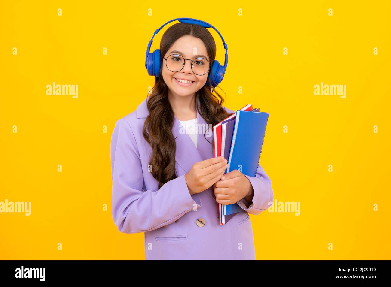 School teen girl in headphones hold book notebooks. Listen to music ...