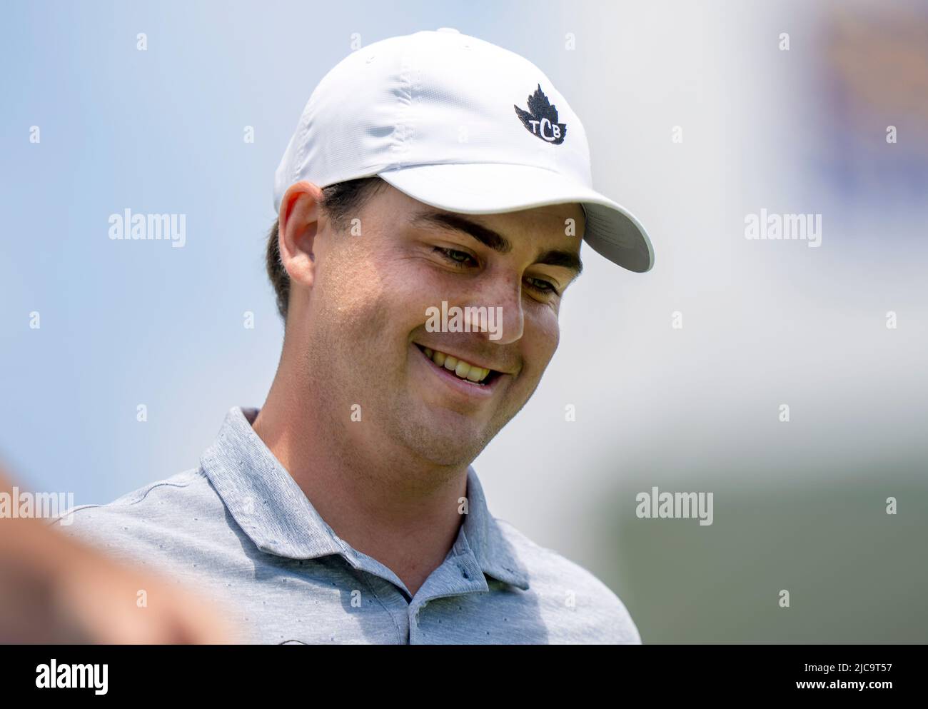 Aaron Cockerill of Canada smiles as he is cheered on the 1st tee in the ...