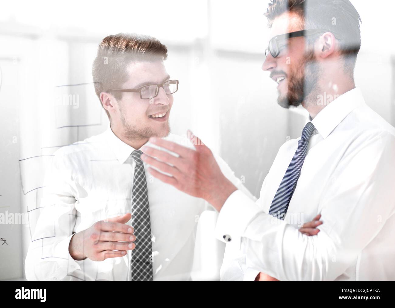 close up.two employees talking standing in the office Stock Photo - Alamy