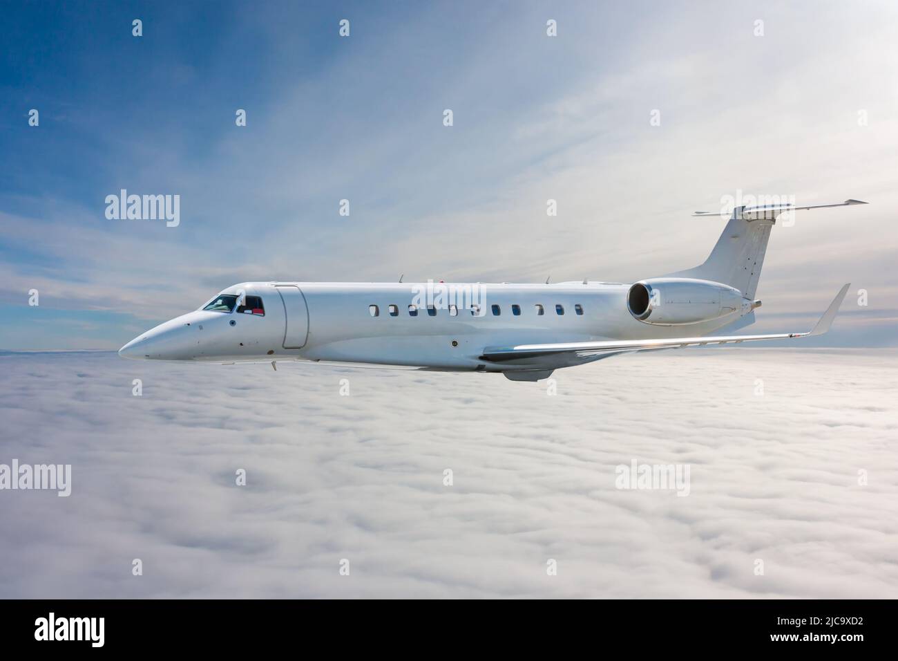 White modern luxury private jet flies in the air above the clouds Stock ...