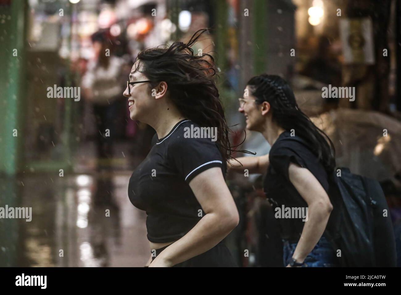 Two women are seen running away from the rain. Heavy rains fall in ...