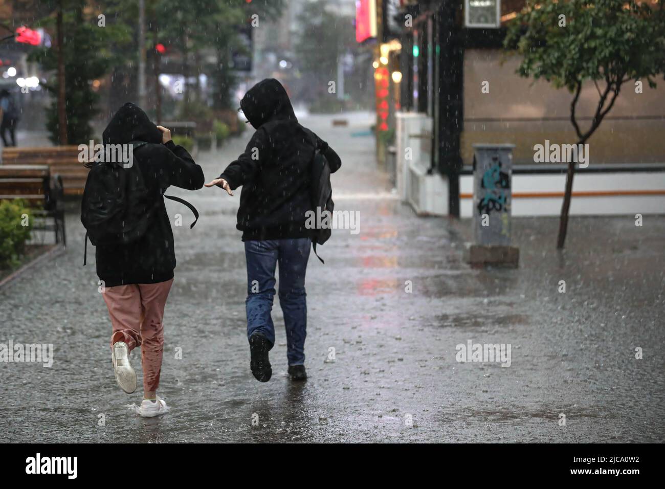 Two women are seen running away from the rain. Heavy rains fall in ...