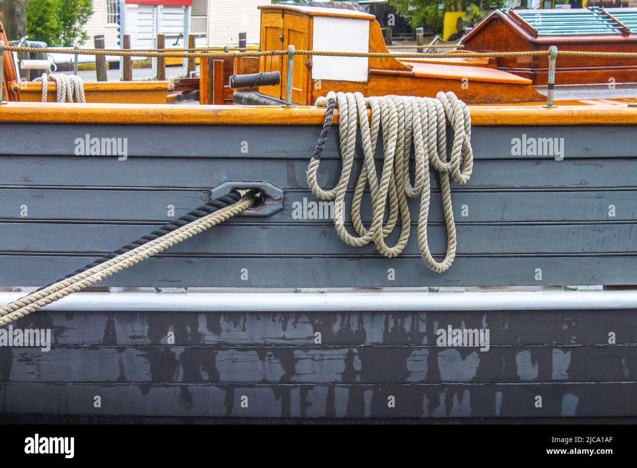 Close-up of ropes looped over the side of a vintage wooden sailing ship ...