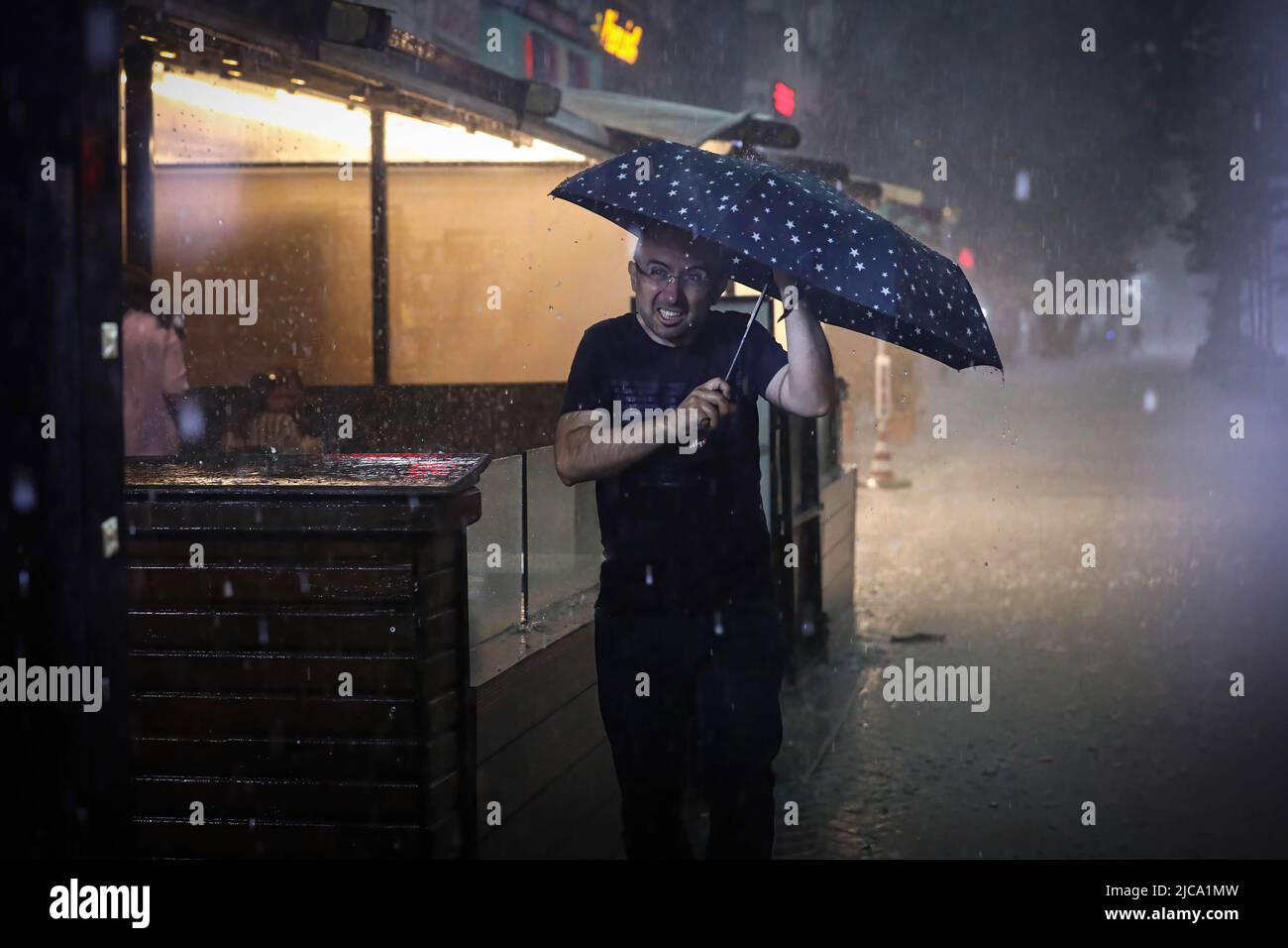 Ankara, Turkey. 11th June, 2022. A man shelters under an umbrella ...