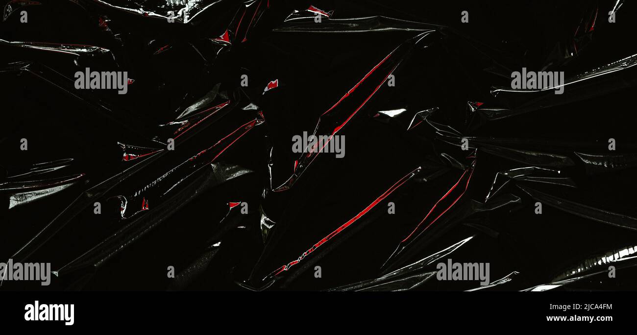 Transparent plastic wrap on black background. Crumpled wrinkled plastic ...