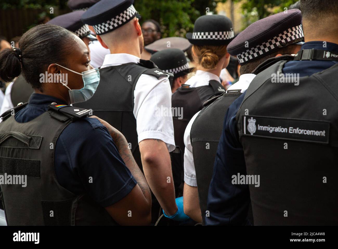 London, UK. 11th June 2022. Immigration and police officers look on ...