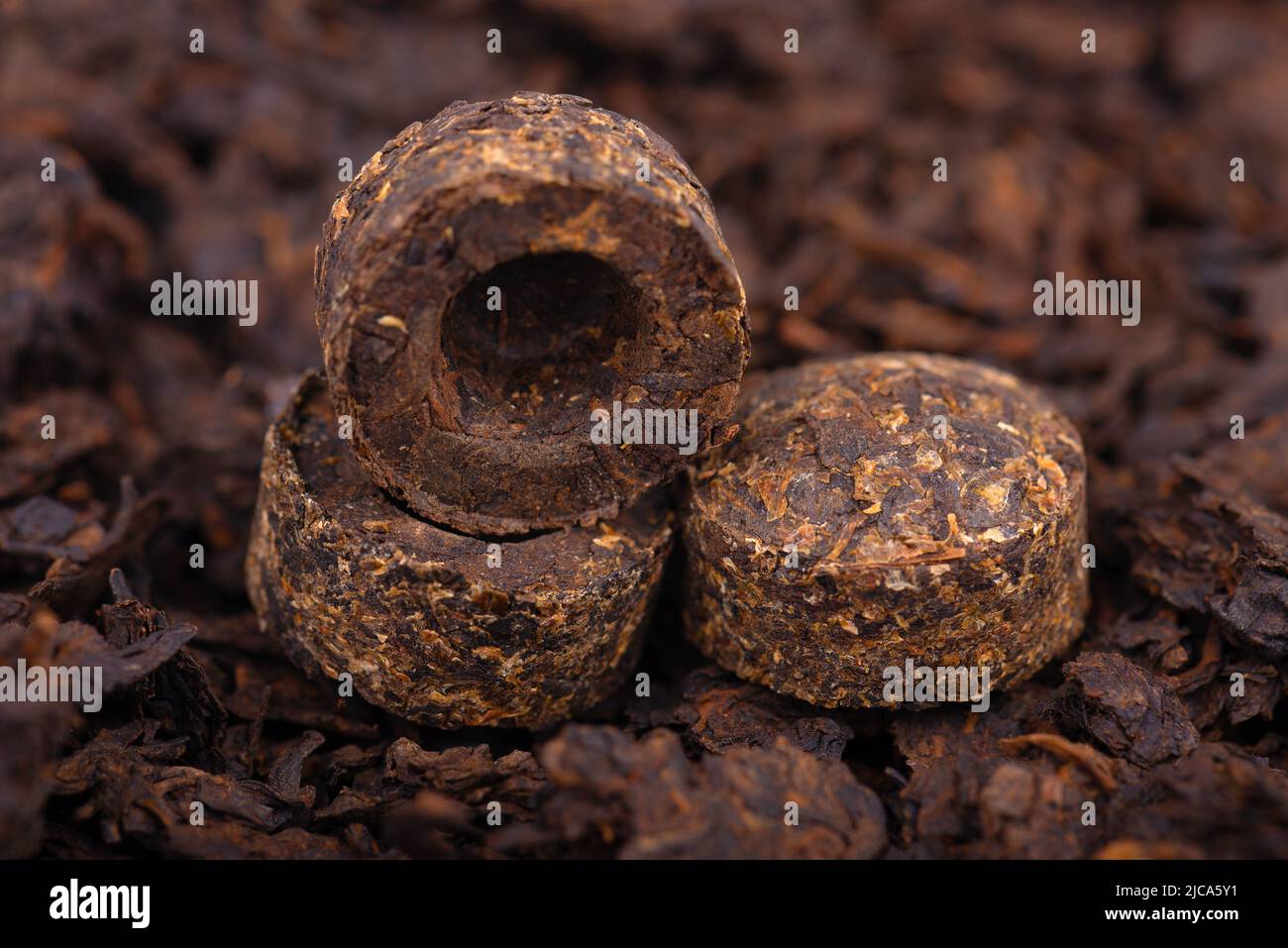 Fermented and compressed tea leaves. Round flat disc of puer tea. Close ...