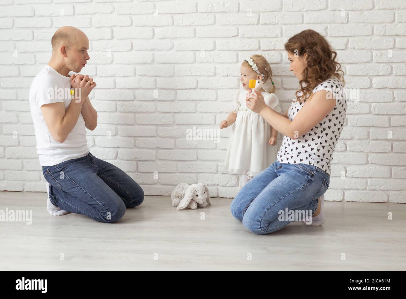 Baby child with hearing aids and cochlear implants plays with parents ...