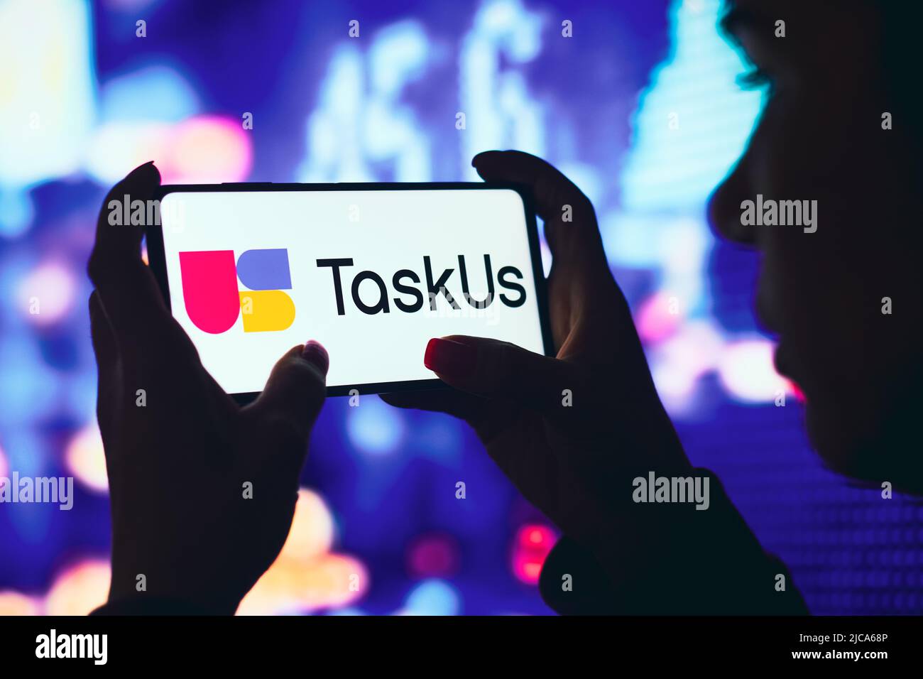 In this photo illustration, a silhouetted woman holds a smartphone with ...