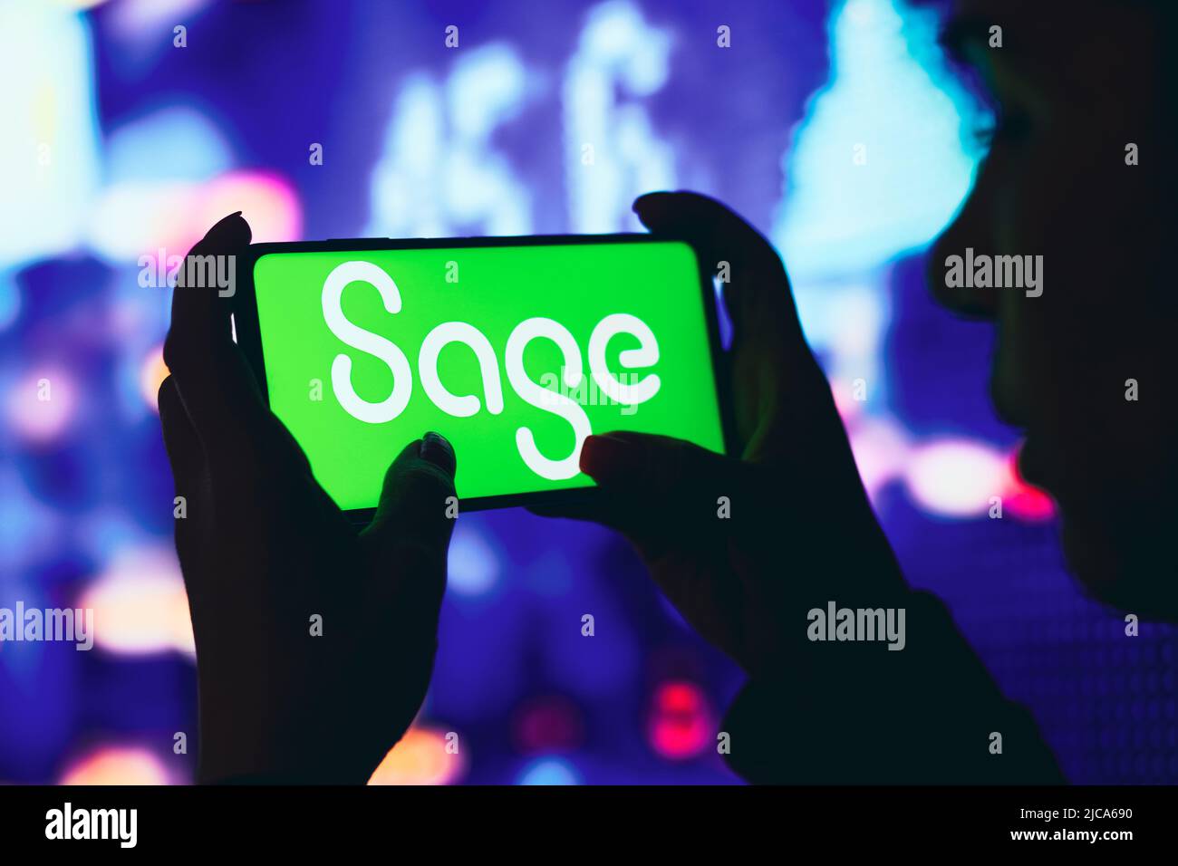 In this photo illustration, a silhouetted woman holds a smartphone with ...