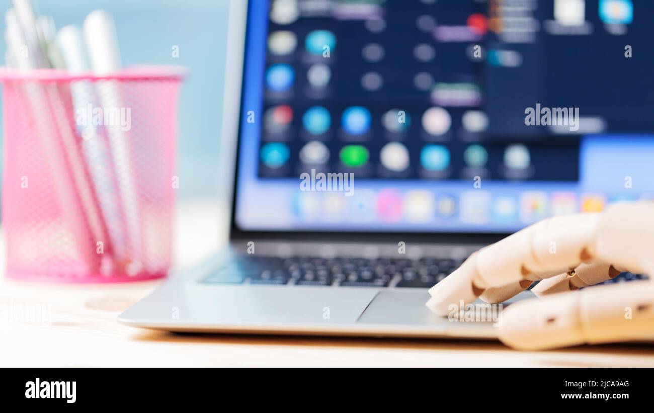 Robotic arm using laptop on a wooden table. Artificial intelligence ...