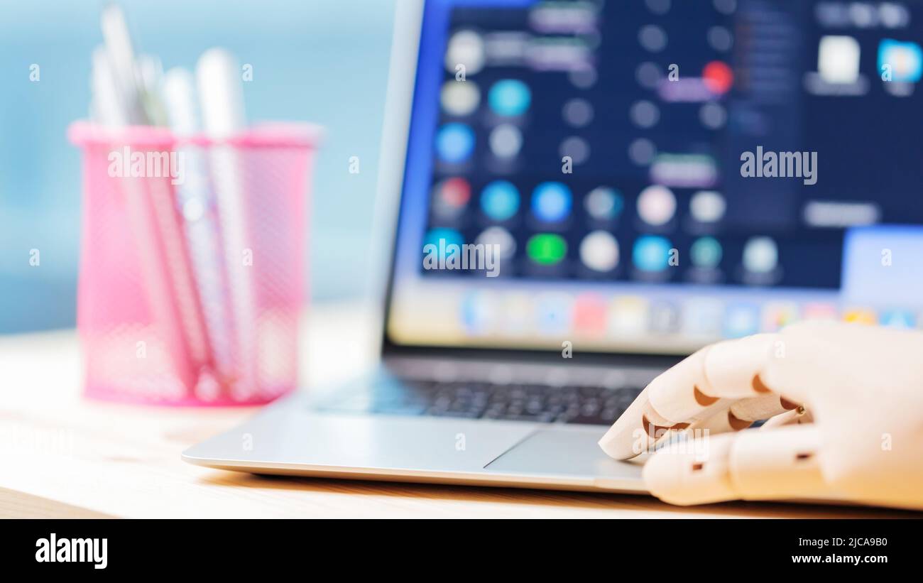 Robotic arm using laptop on a wooden table. Artificial intelligence ...