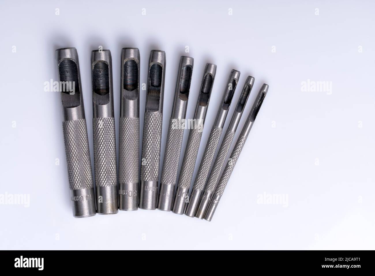 Macro detail of a set of steel punches isolated on white Stock Photo ...
