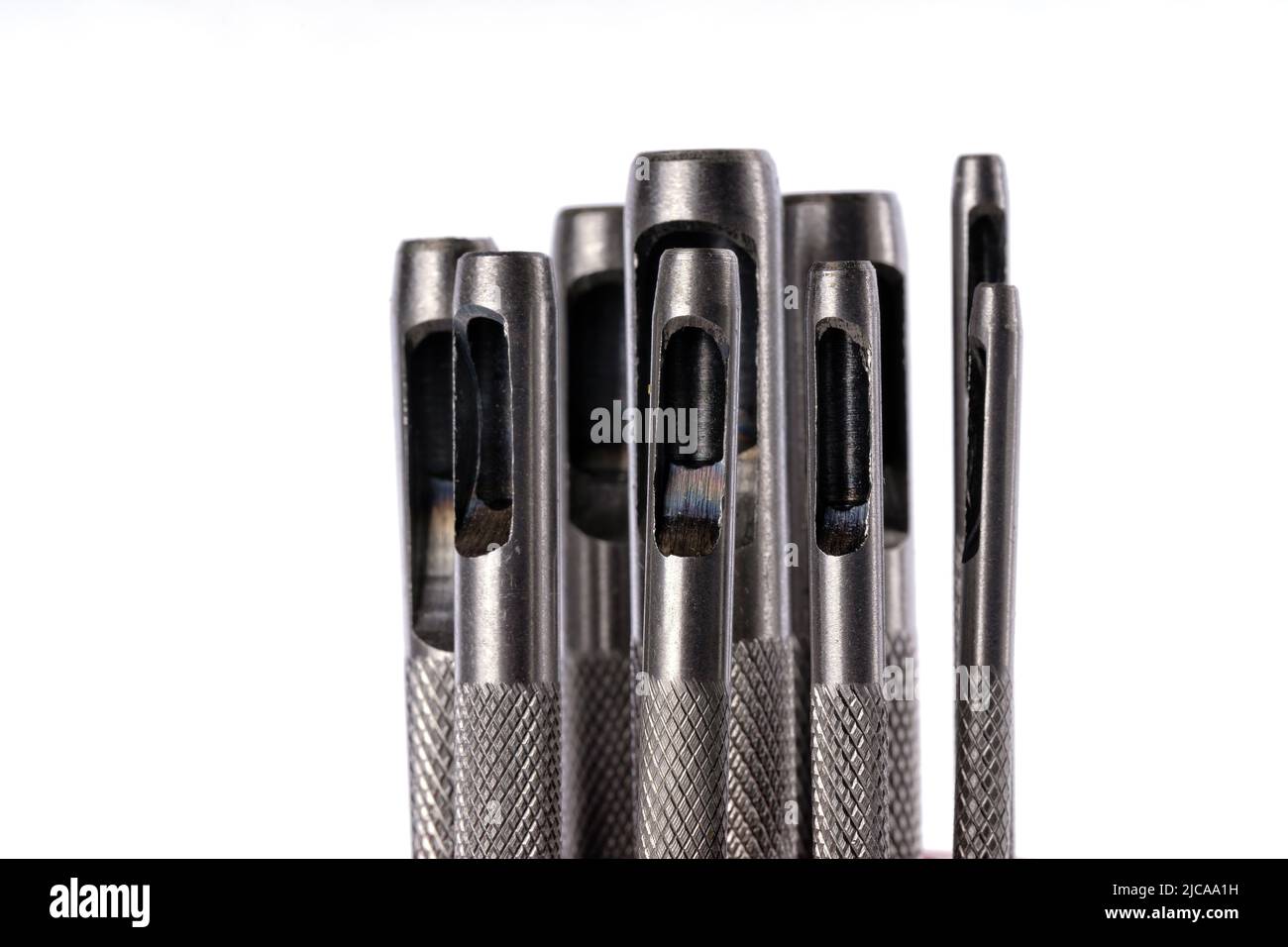 Macro detail of a set of steel punches isolated on white background ...