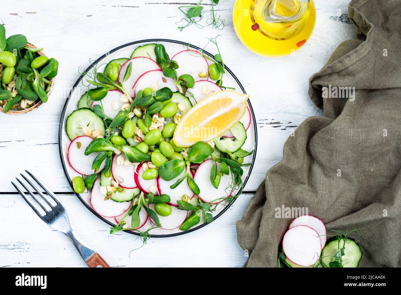 Fresh vegan salad with radish, cucumber, green pea, sunflower and soy ...