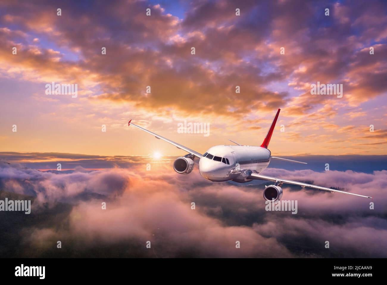 Airplane is flying above the clouds at sunset in summer Stock Photo - Alamy