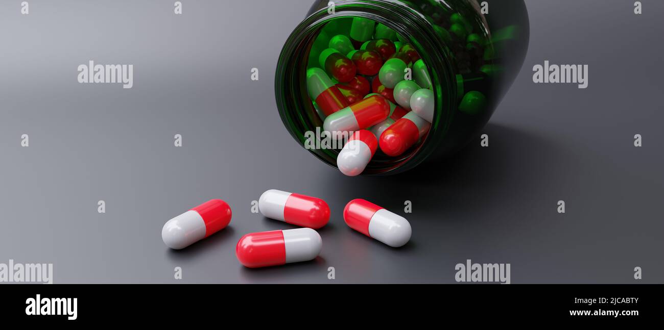Medicine capsule white and red color scattered out of green bottle on ...