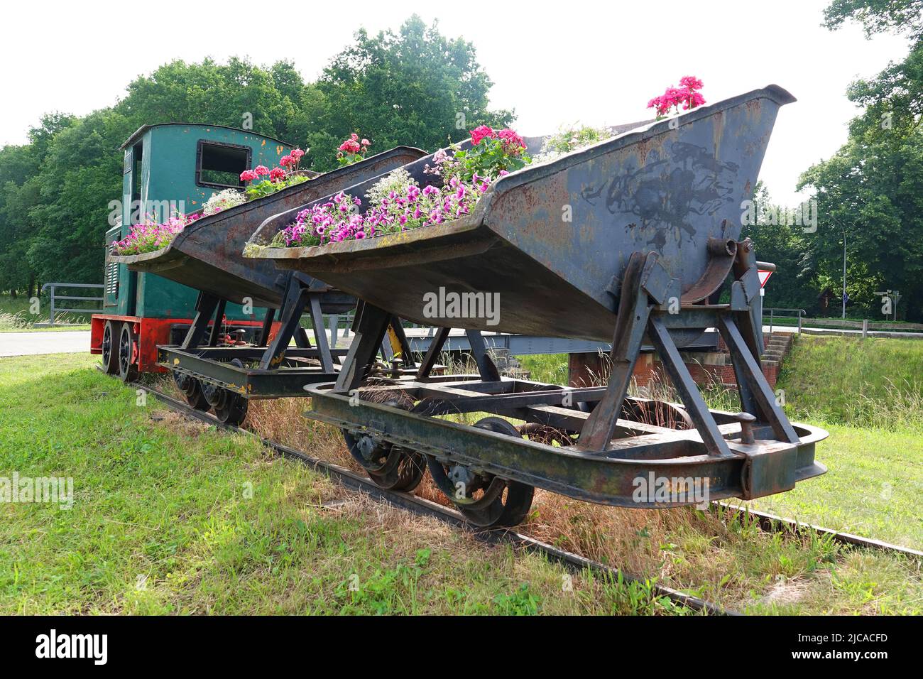 Vintage narrow gauge train with tipper wagons used as flower planters ...