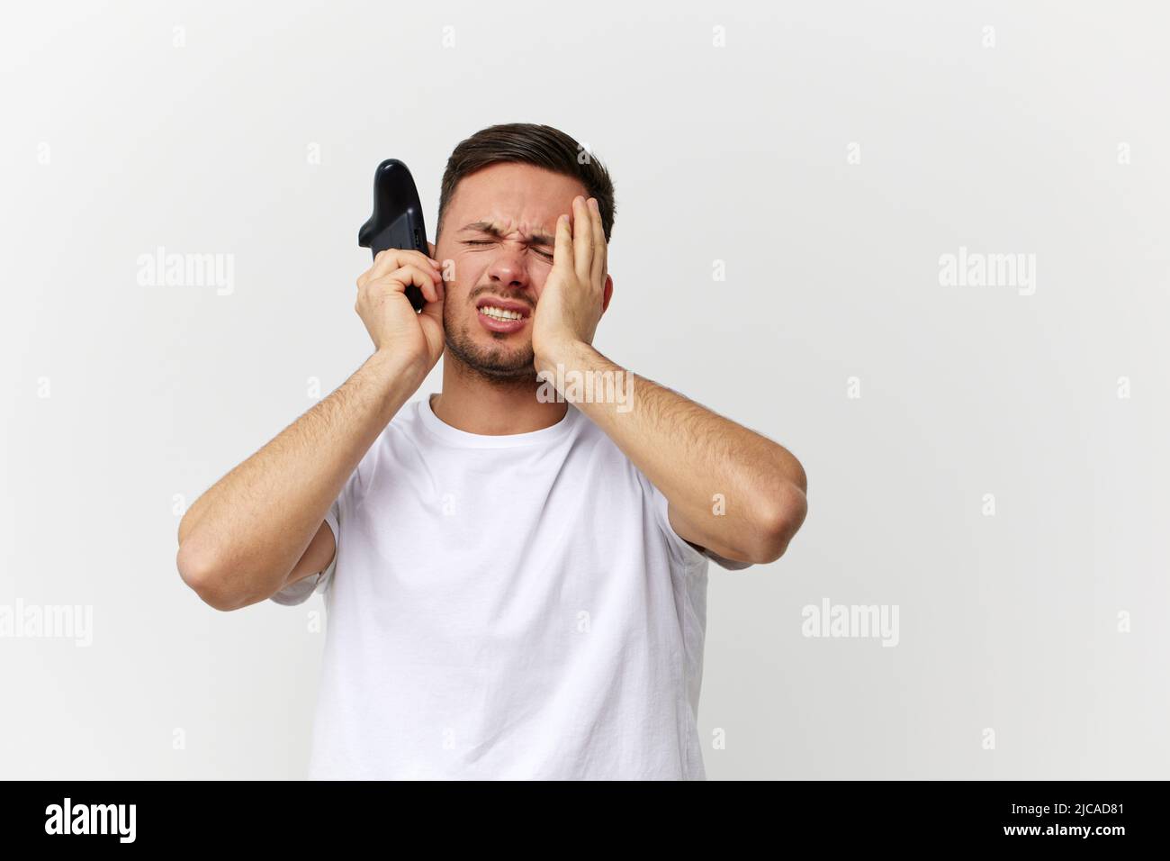 Tired frustrated sad tanned handsome man in basic t-shirt lose game ...
