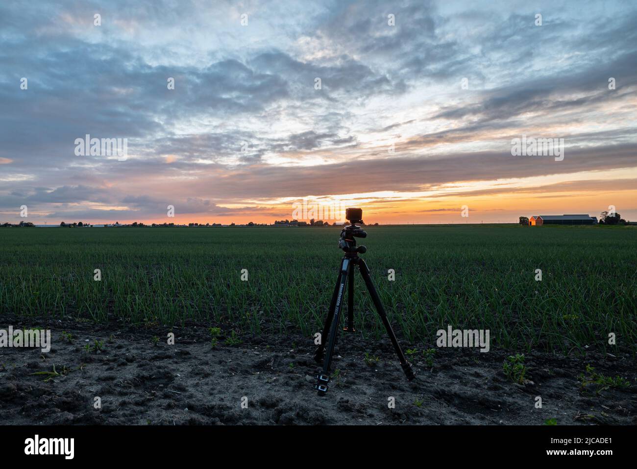 Photo camera on tripod to capture the sunset Stock Photo - Alamy