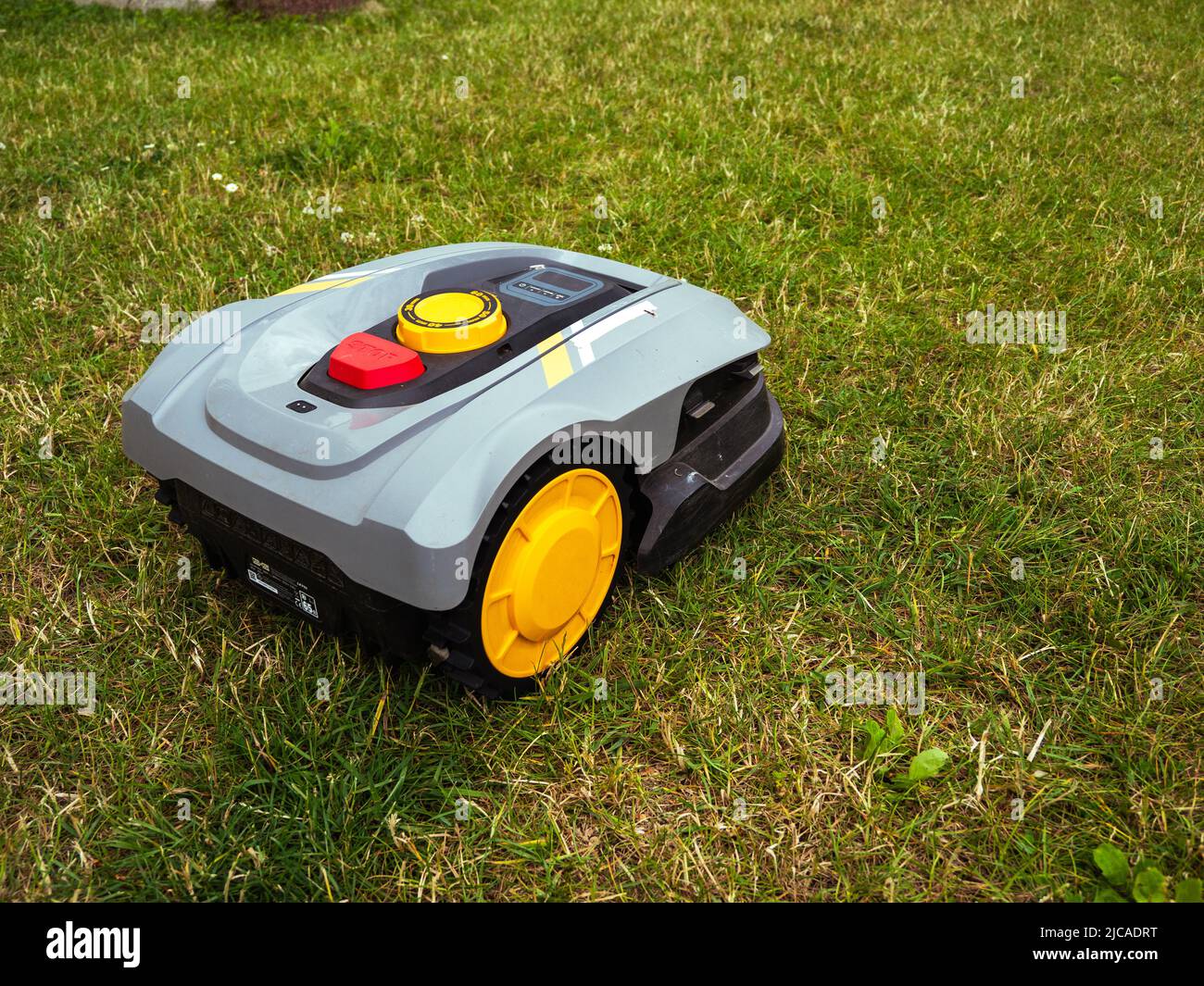 Robot lawnmower. The electronic lawn mower mows the grass Stock Photo ...
