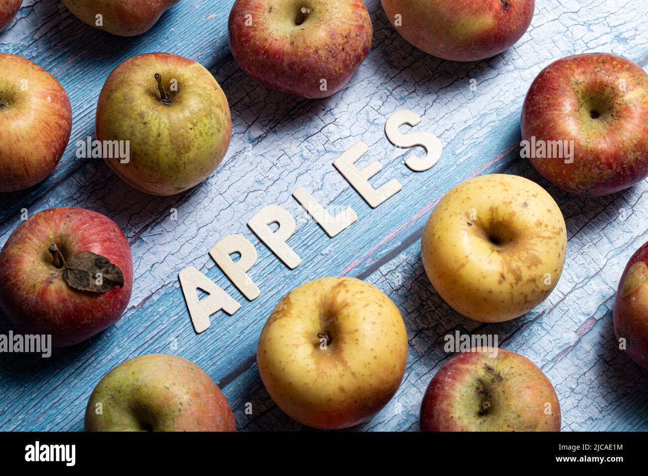 Many yellow and red apples fruit with apples word written on wooden ...