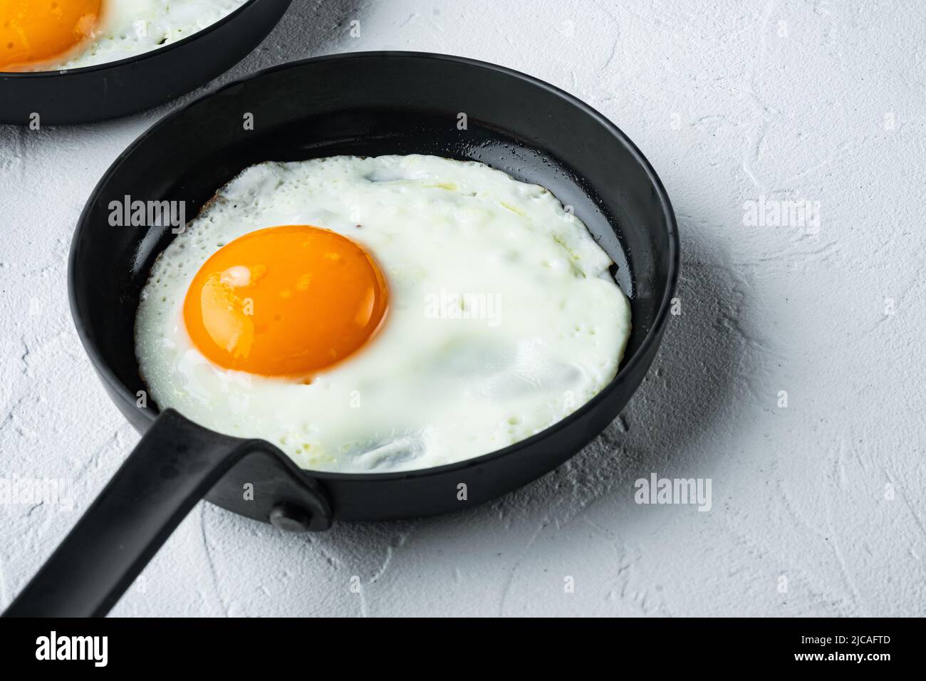Fried Egg with ingredients in cast iron frying pan, on white background ...