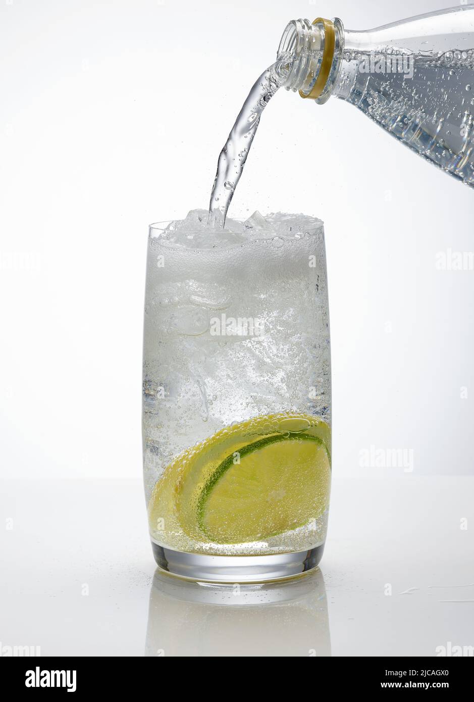 water pouring into glass of ice and lemon slices on white background Stock Photo - Alamy