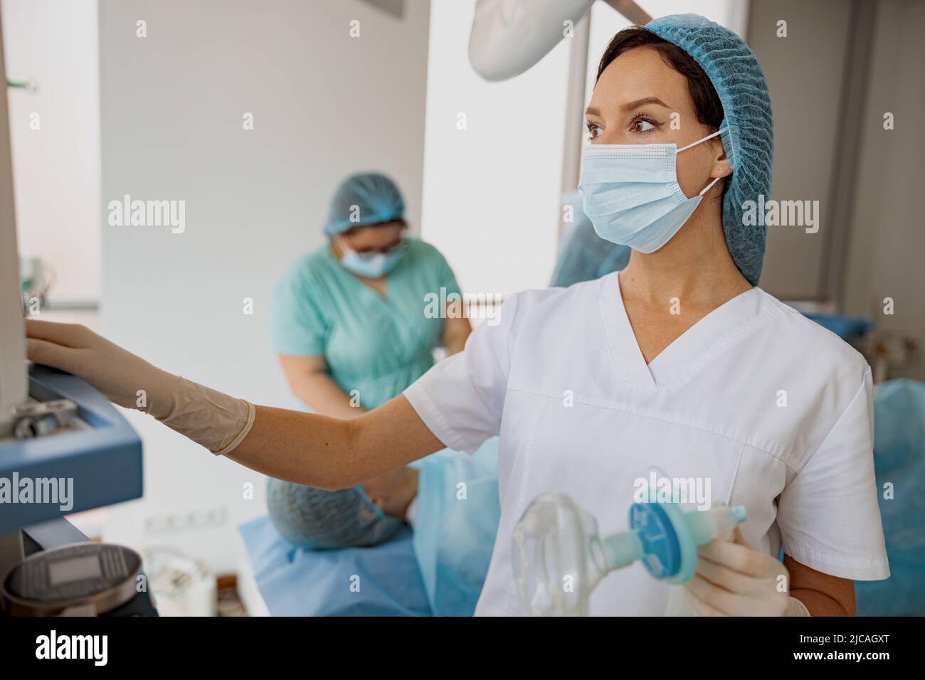 Nurse holding breathing mask for anesthesia standing in operation room ...