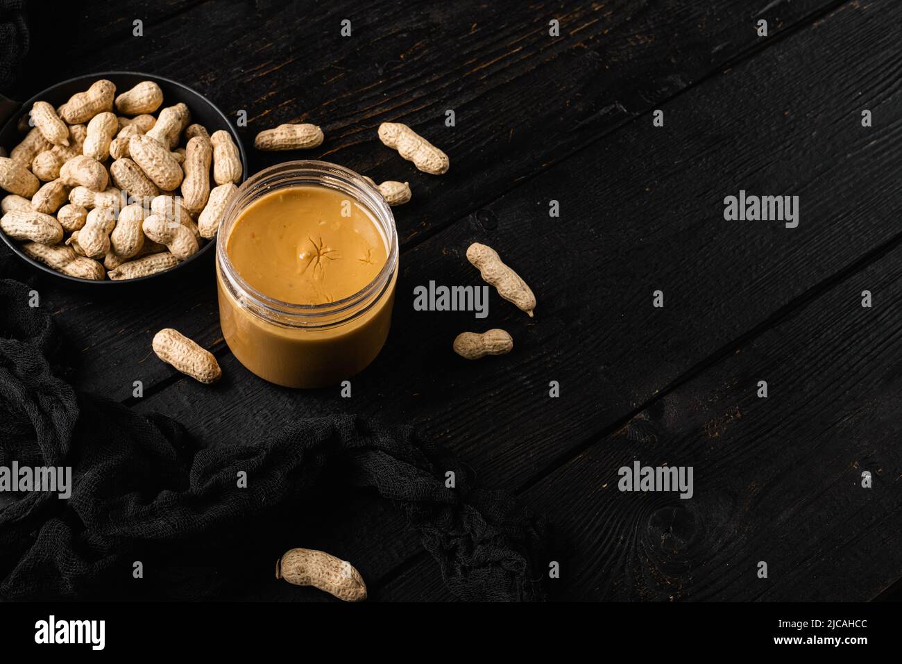 Fresh made creamy Peanut Butter, on black wooden table background, with ...