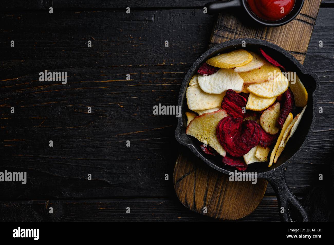 Beetroot carrot and turnip chips, on black wooden table background, top ...