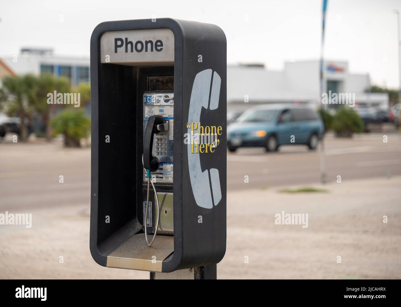 Public Pay Phone, coin operated, next to a busy street is an old and ...