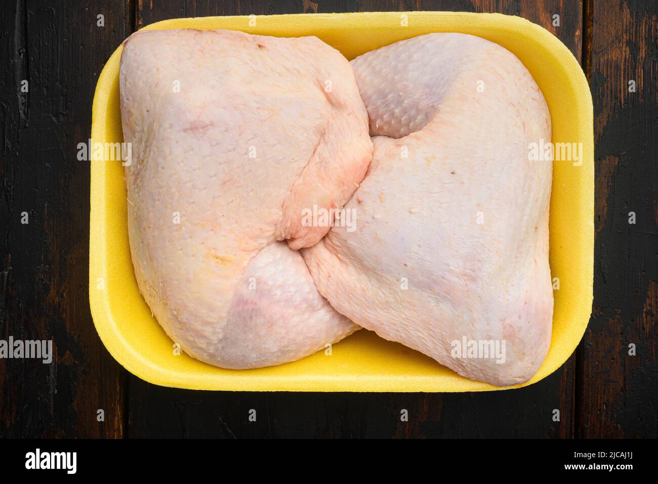 Fresh Chicken Whole Legs, in Foam Tray Pack, on old dark wooden table ...