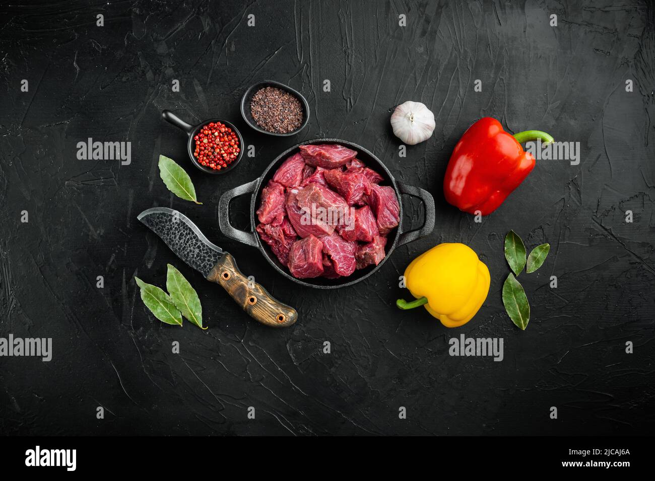 Beef stew prepared for goulash cooking with sweet bell pepper, in cast ...