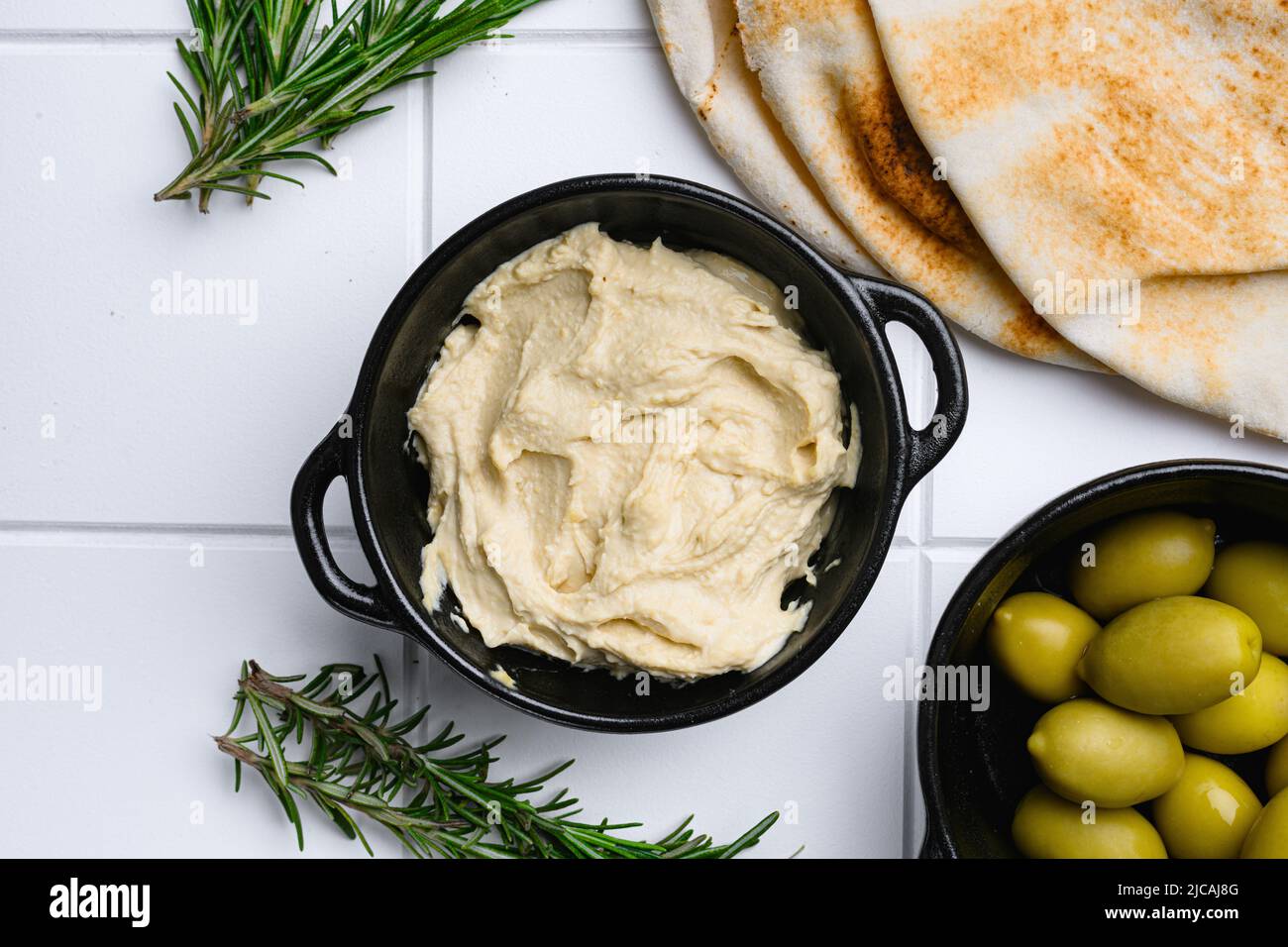 Healthy Creamy Hummus set, on white ceramic squared tile table ...