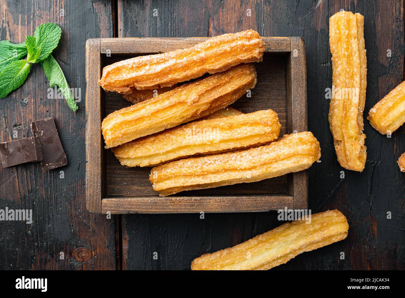 Traditional churros sticks with cinnamon and sugar powder, on old dark ...