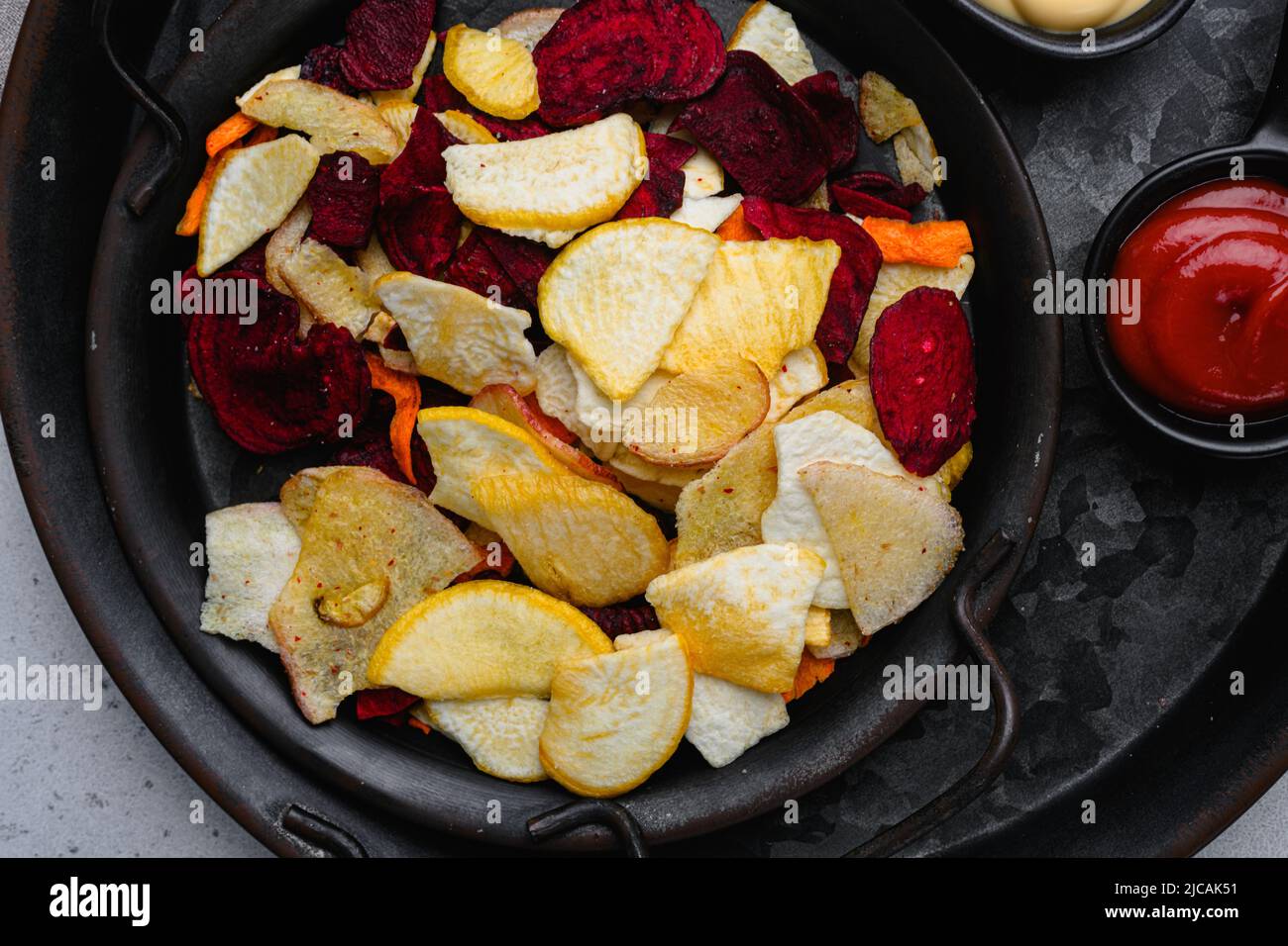 Root Vegetable Crisps, on gray stone table background, top view flat ...
