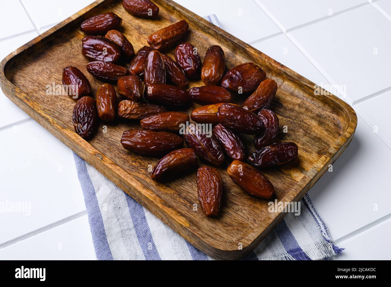 Traditional arabic dry dates set, on white ceramic squared tile table ...